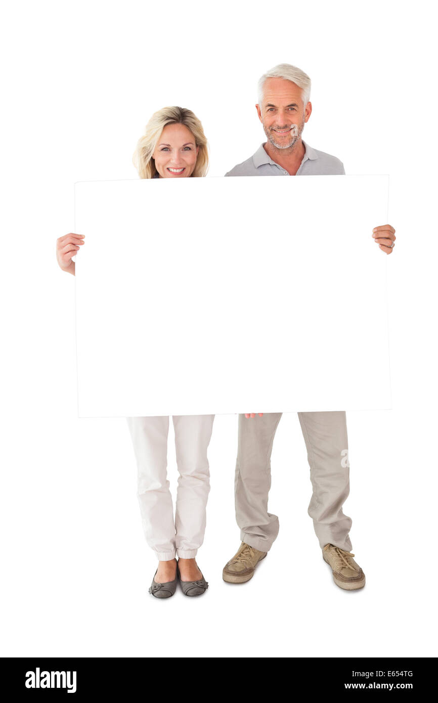 Happy couple holding large poster Stock Photo - Alamy