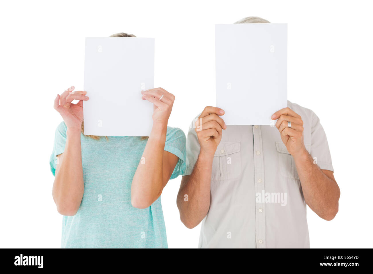 Couple holding paper over their faces Stock Photo - Alamy
