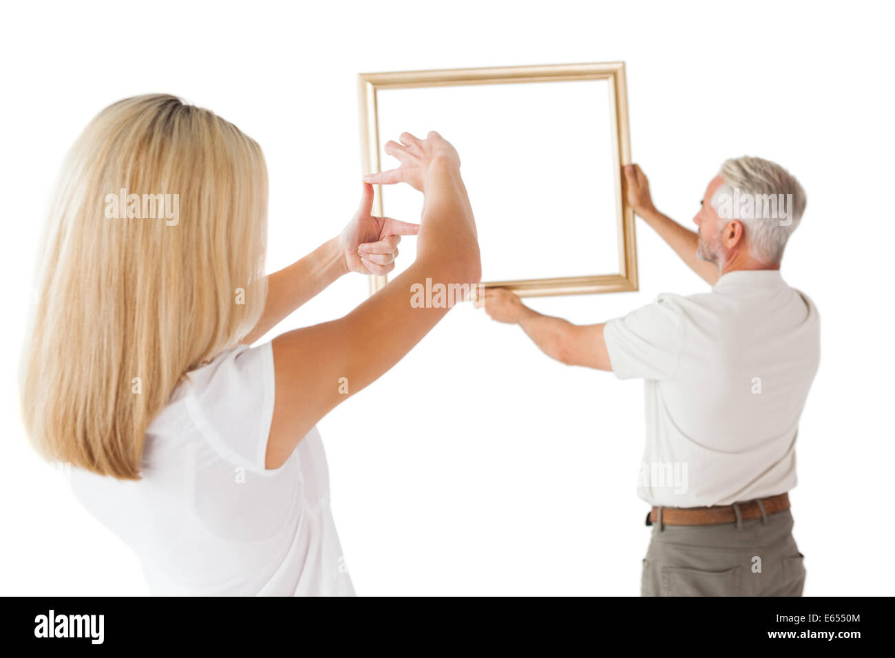 Couple hanging a frame together Stock Photo - Alamy