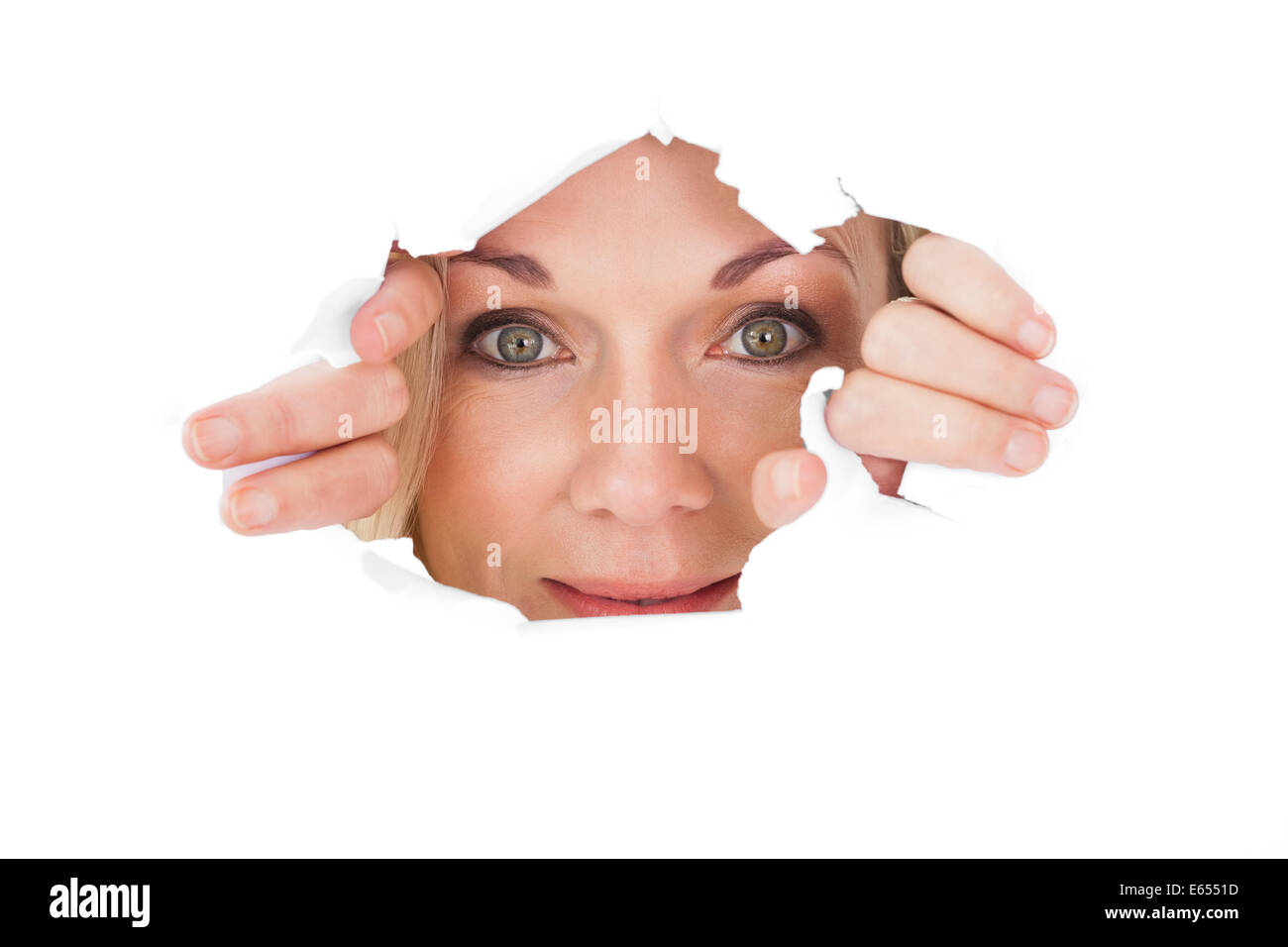 Woman looking through torn paper Stock Photo - Alamy