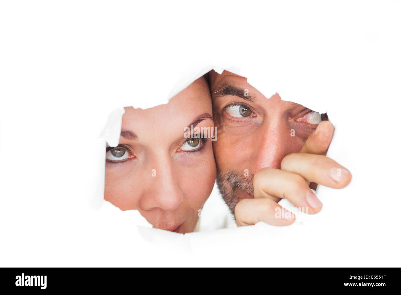 Couple looking through torn paper Stock Photo - Alamy