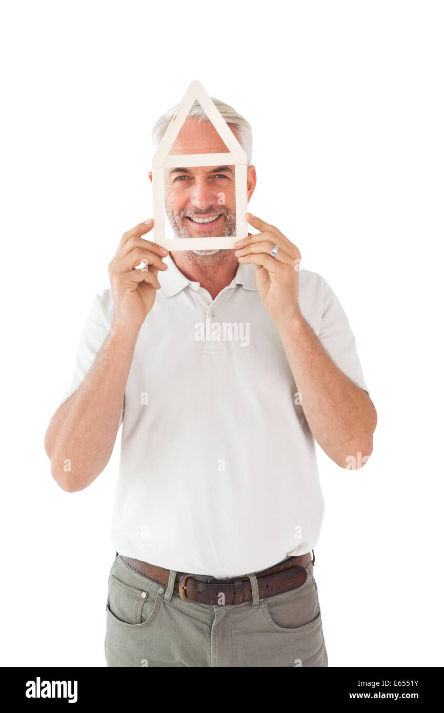 Happy man holding house outline over face Stock Photo - Alamy