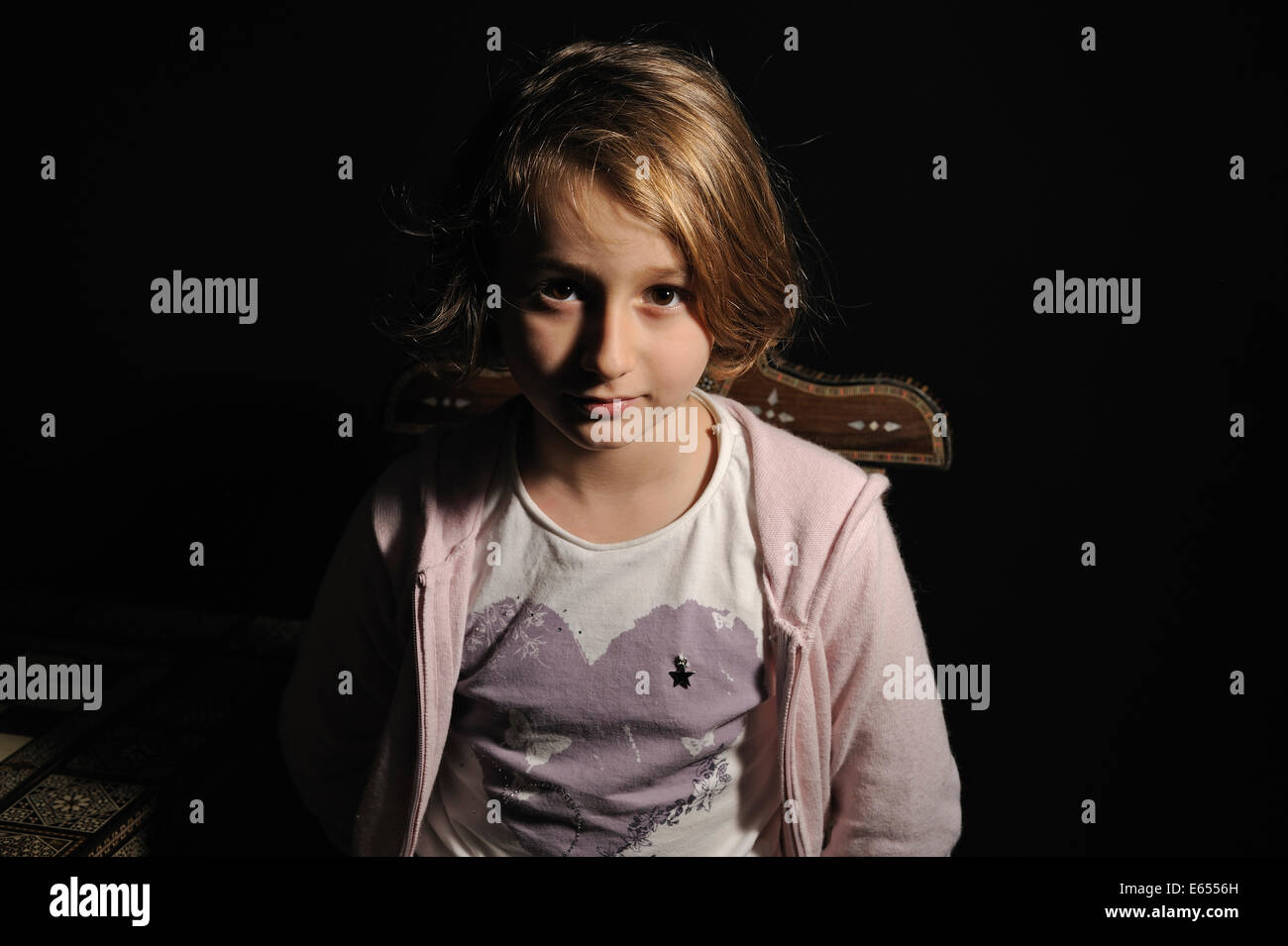 Portrait of young girl (aged 8) with black background Stock Photo - Alamy