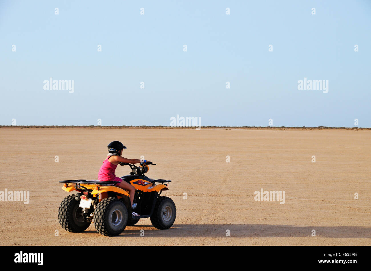 Young girl speeding on ATV quad bike in the desert, Tunisia, North ...