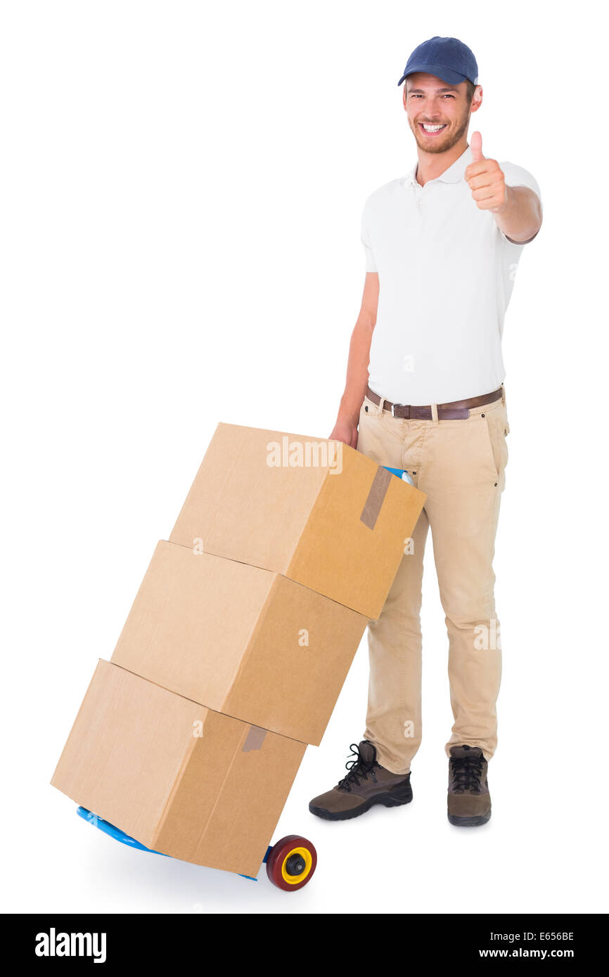Happy delivery man pushing trolley of boxes Stock Photo - Alamy