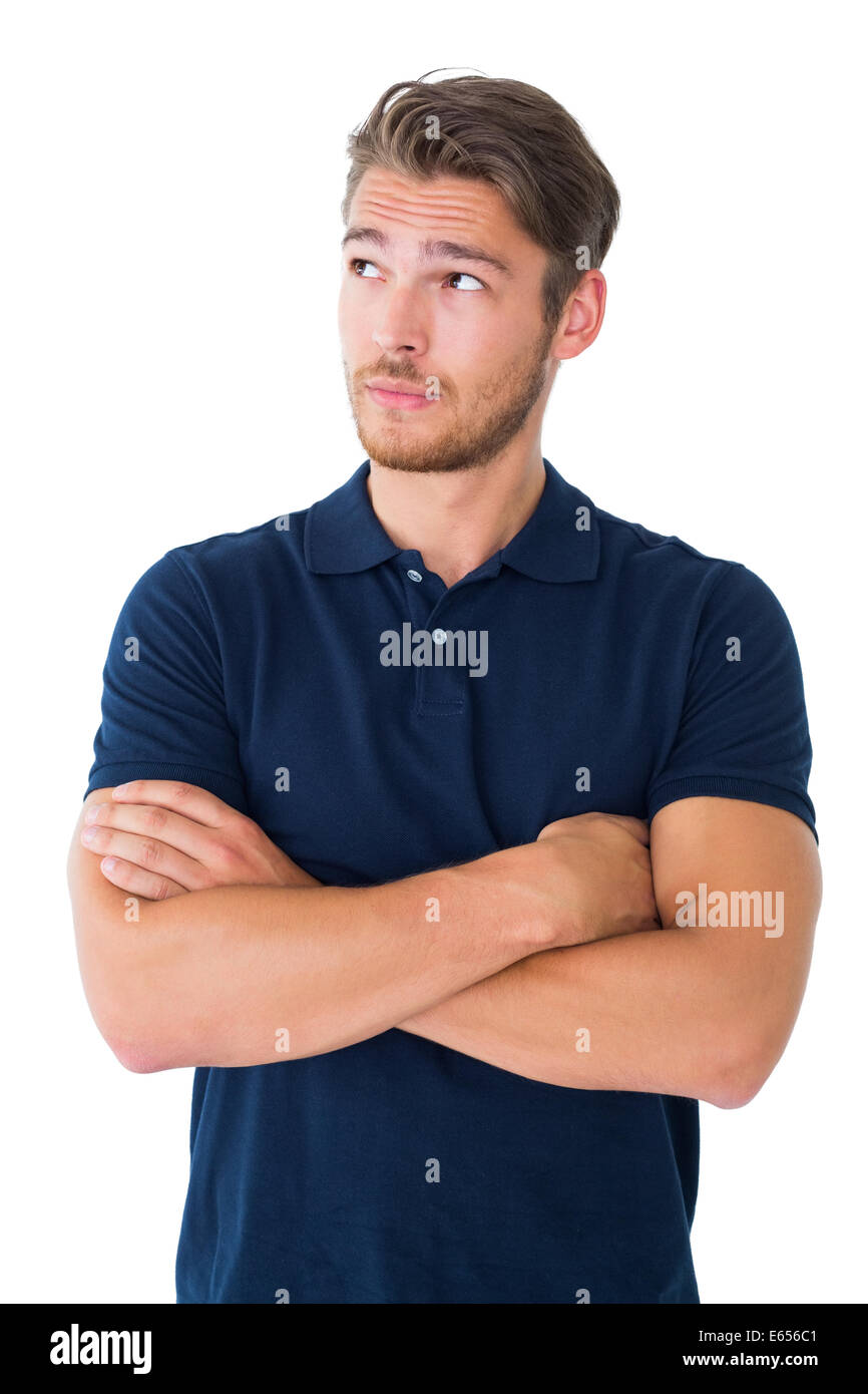 Handsome young man thinking with arms crossed Stock Photo - Alamy