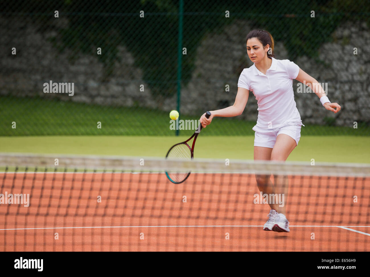 Pretty tennis player hitting ball Stock Photo - Alamy