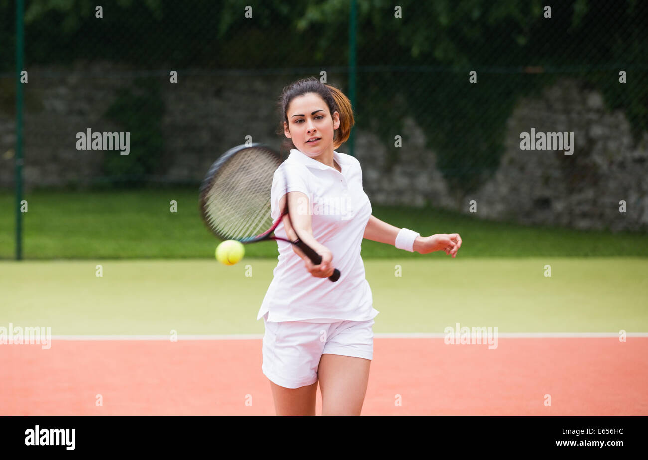 Young tennis player hitting ball Stock Photo - Alamy