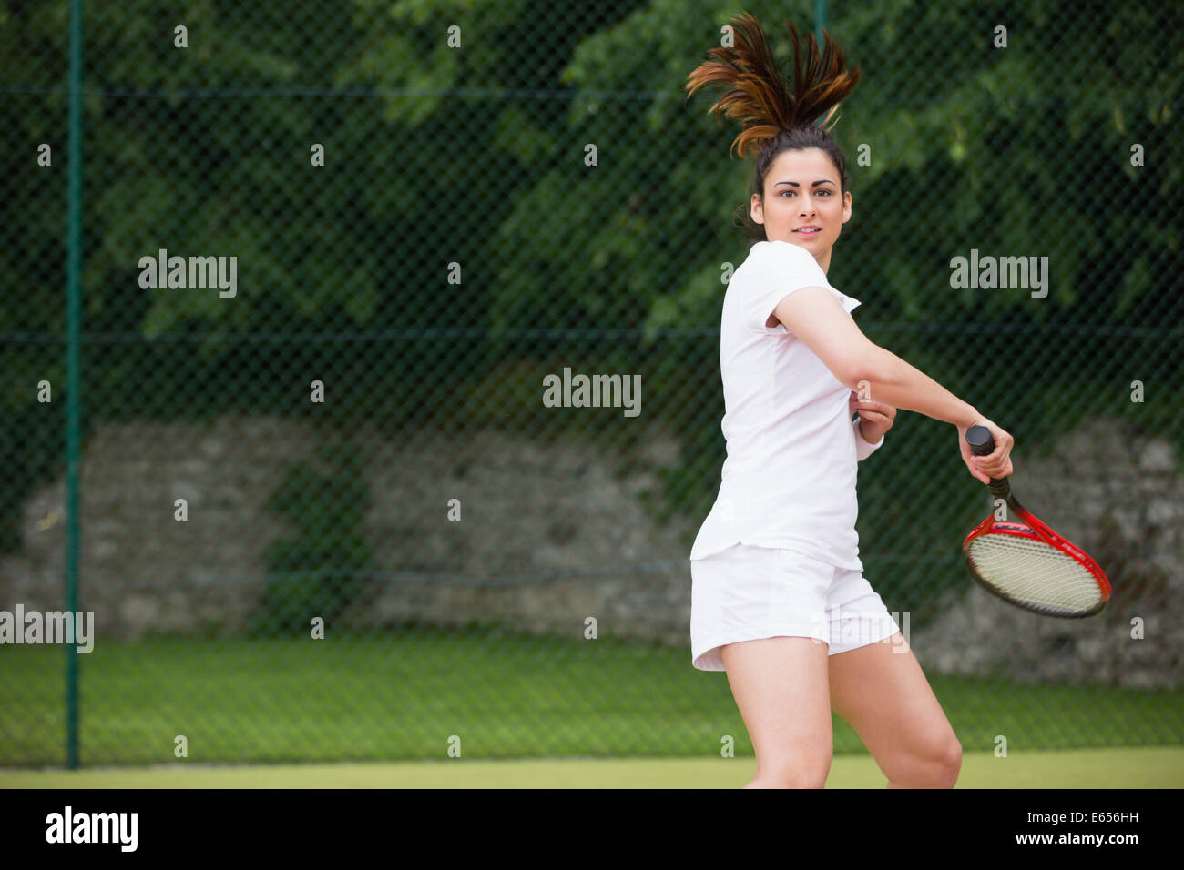 Pretty tennis player playing on court Stock Photo - Alamy
