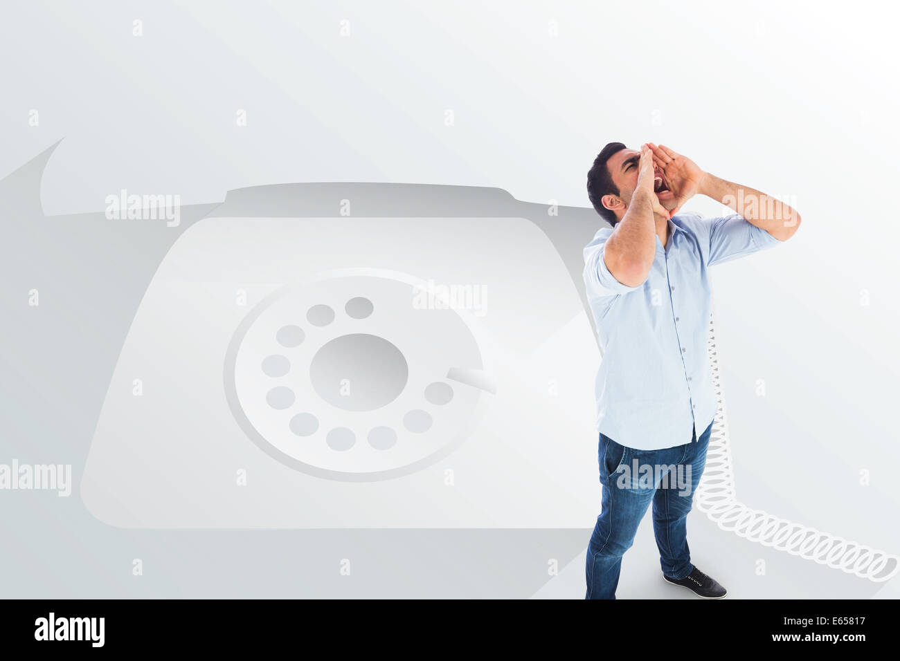 Shouting casual man standing against retro telephone Stock Photo - Alamy
