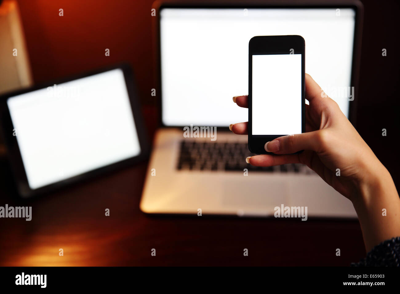 Closeup image of a female hand holding smartphone with tablet computer ...