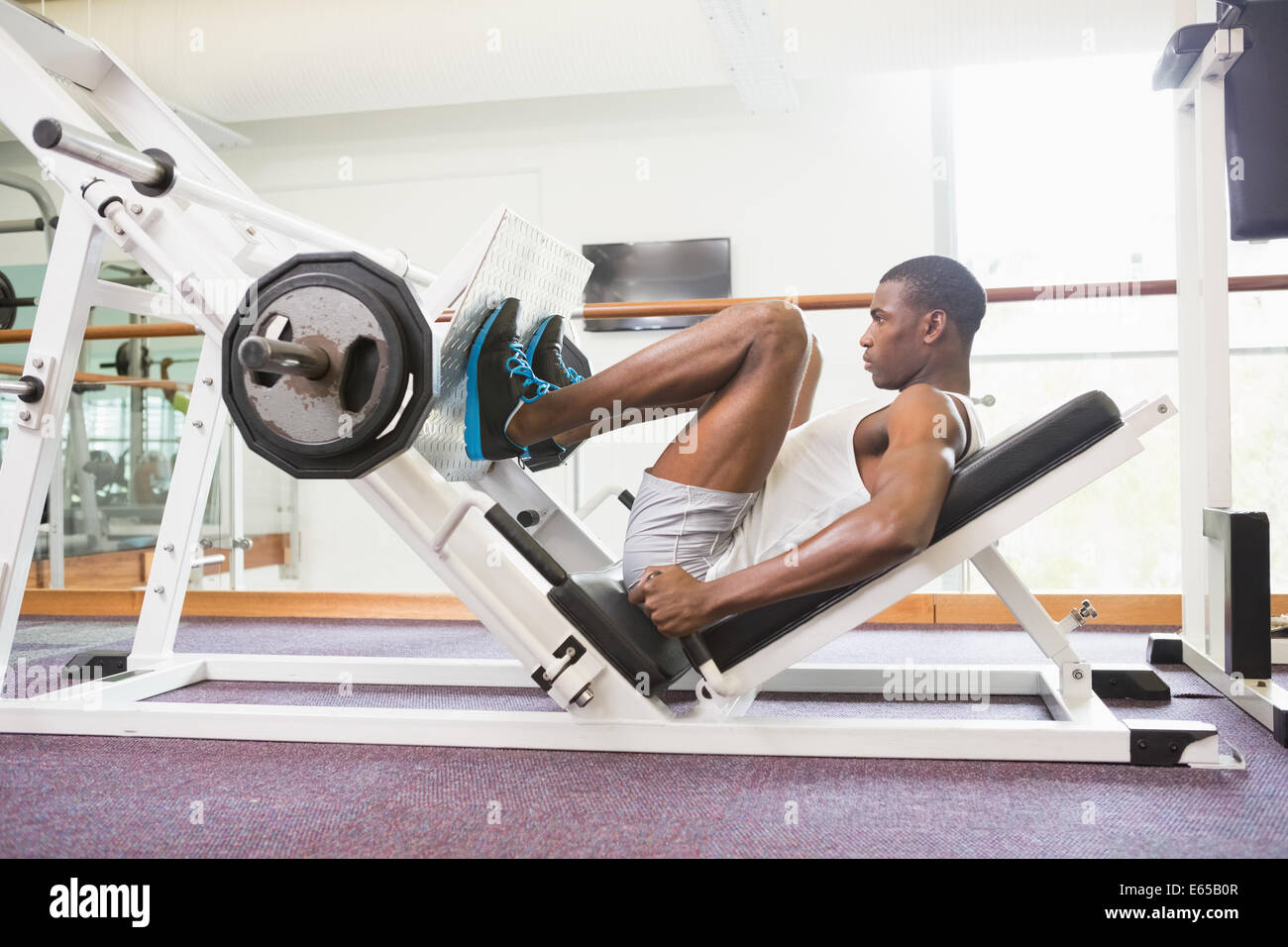 Male weightlifter doing leg presses in gym Stock Photo - Alamy