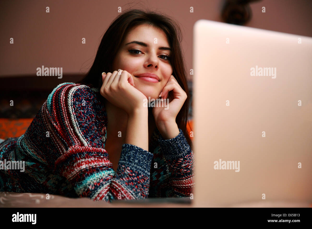 Happy woman lying on the bed with laptop Stock Photo - Alamy