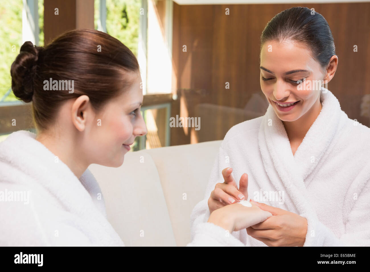 Woman applying cream to friend's hand Stock Photo - Alamy