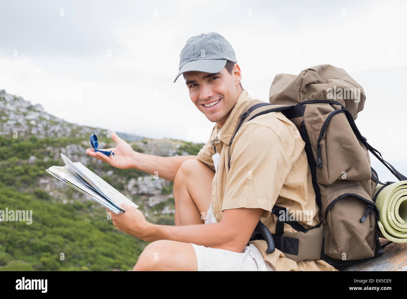 Hiking man with map on mountain terrain Stock Photo - Alamy