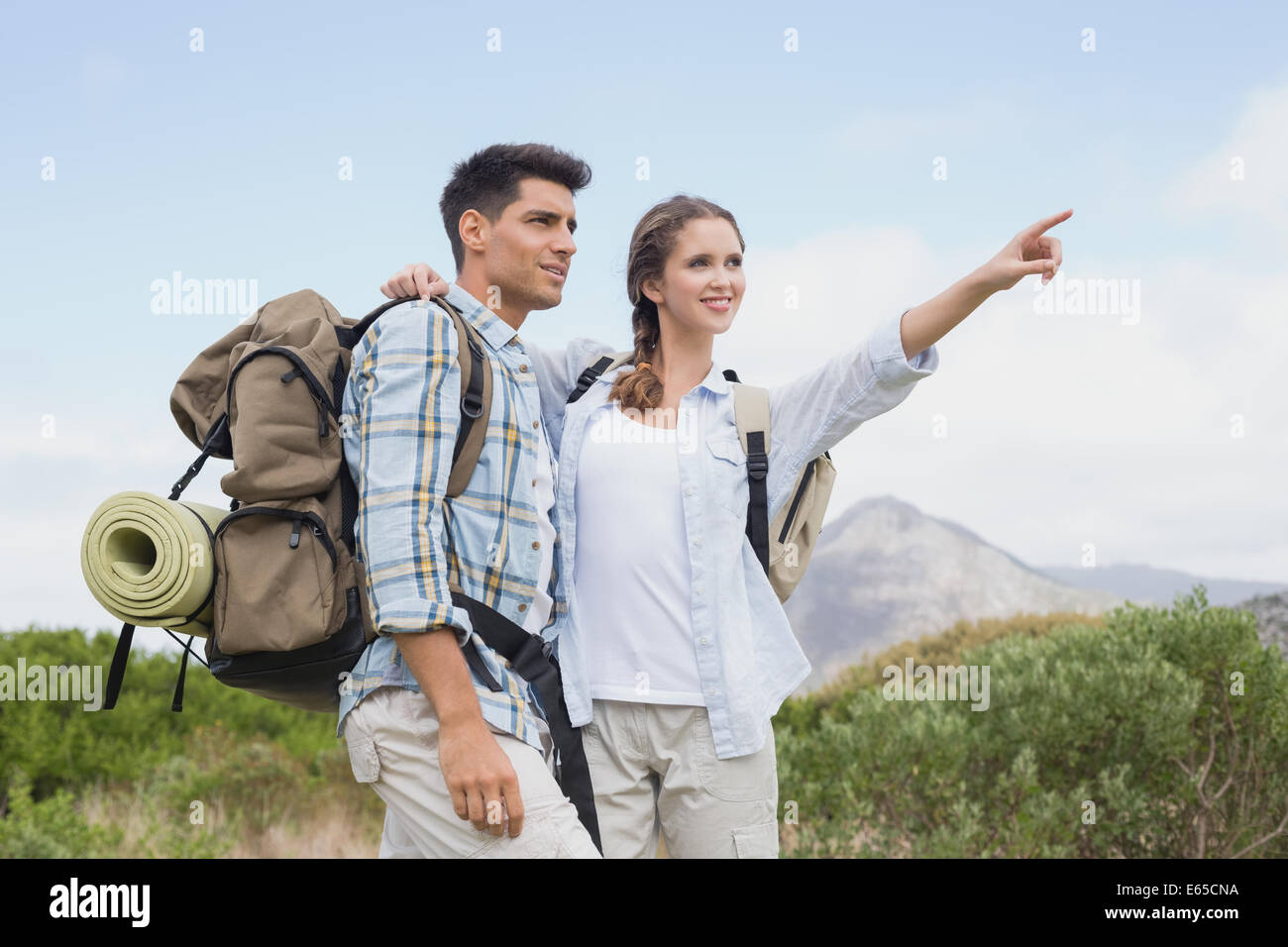 Couple pointing and smiling on country terrain Stock Photo - Alamy