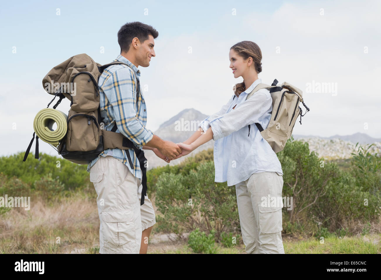 Hiking couple holding hands on mountain terrain Stock Photo - Alamy