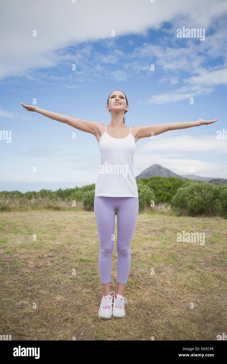 Woman standing with arms raised on countryside landscape Stock Photo ...