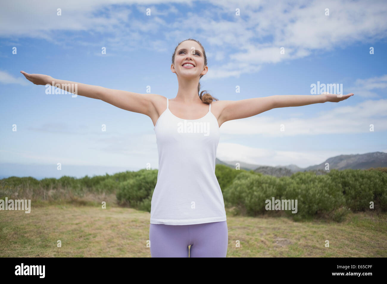 Woman standing with arms raised on countryside landscape Stock Photo ...