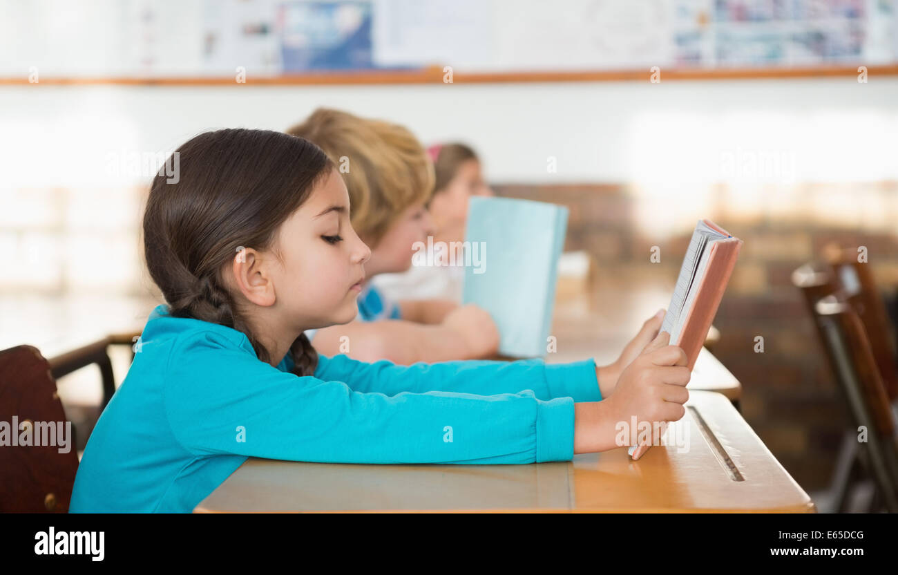 Pupils sitting in classroom reading books Stock Photo - Alamy