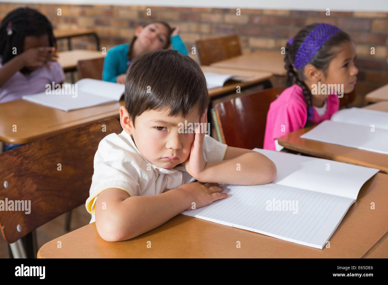 Bored pupil sitting at his desk Stock Photo - Alamy