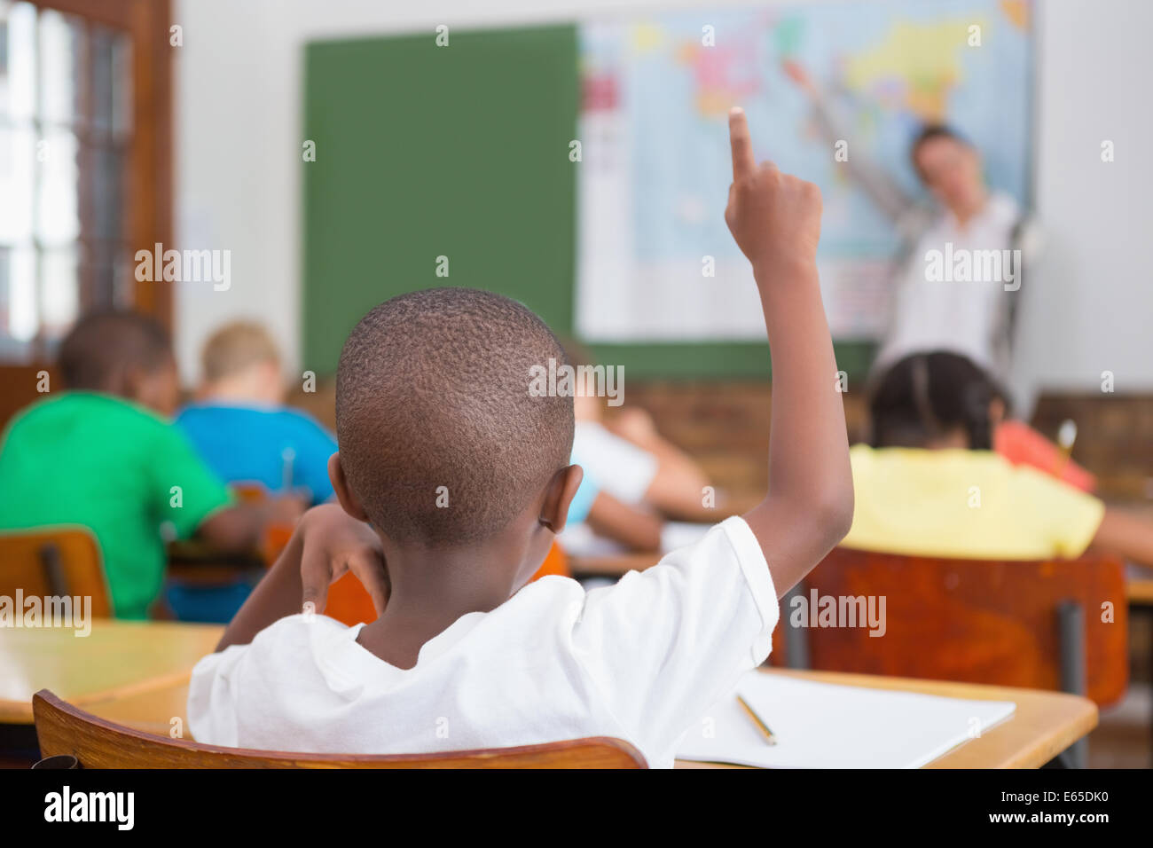 Pupil raising hand in classroom Stock Photo - Alamy
