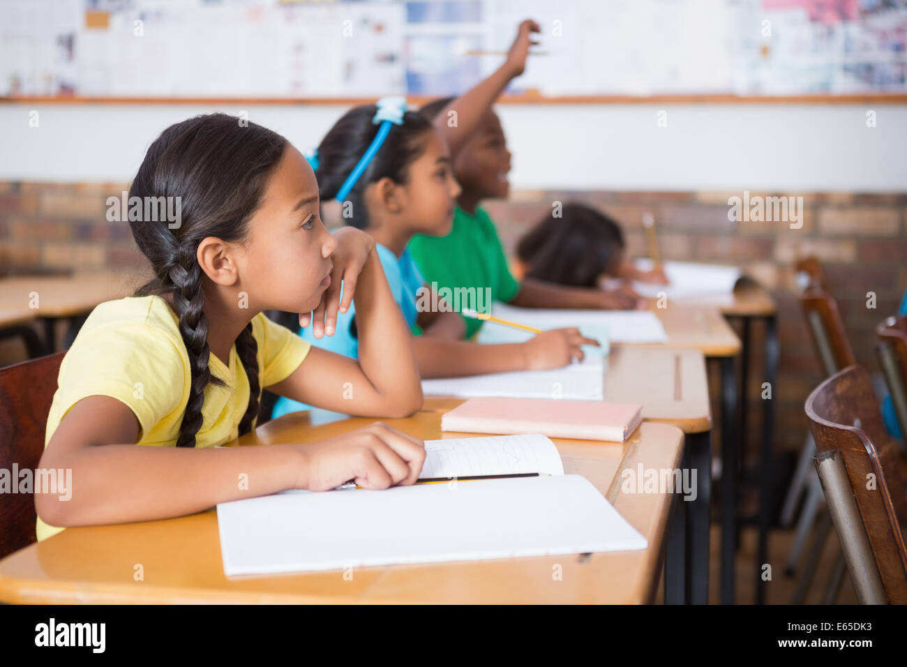 Cute pupil raising hand in classroom Stock Photo - Alamy