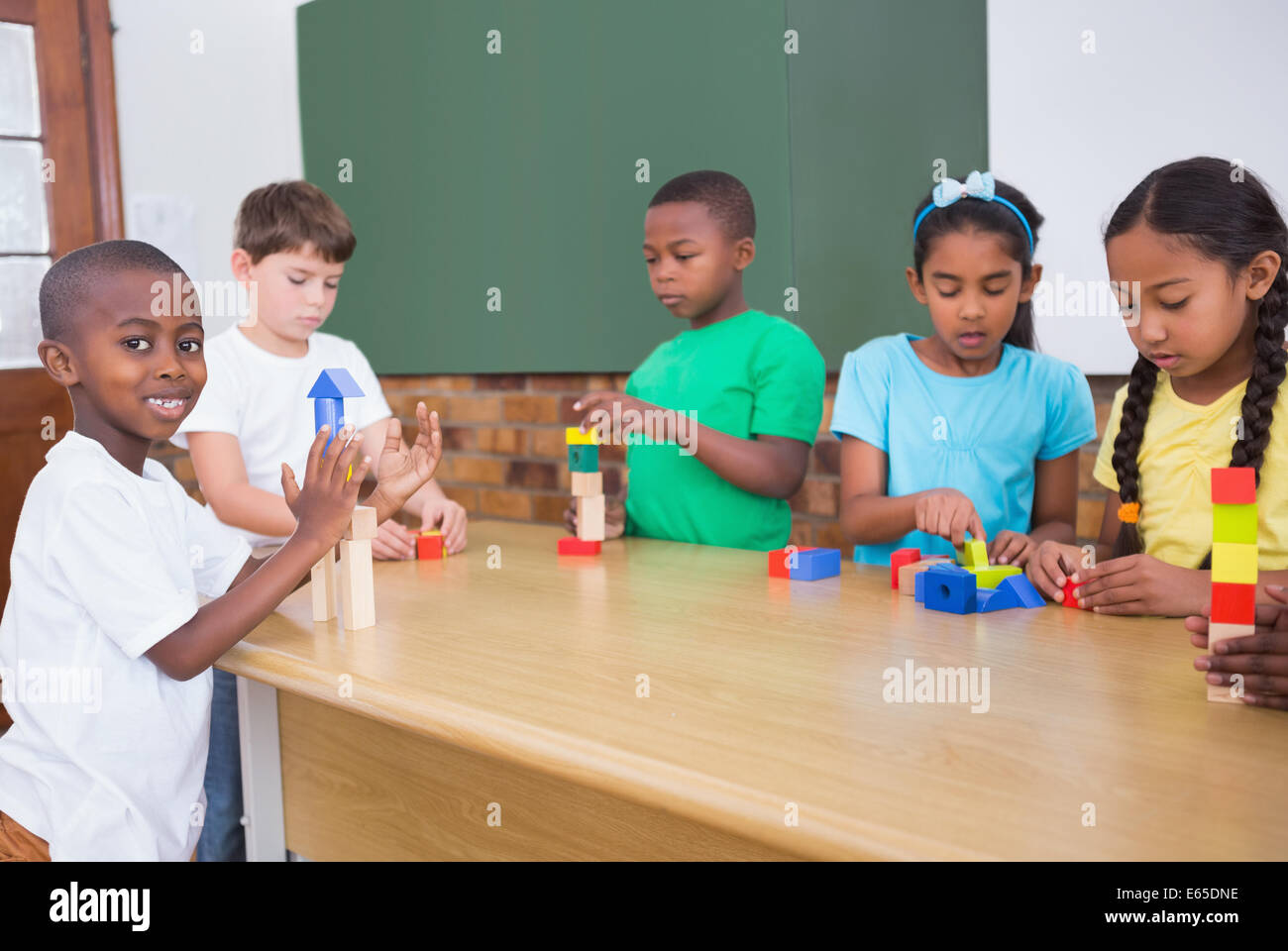 Cute pupils playing with building blocks Stock Photo - Alamy