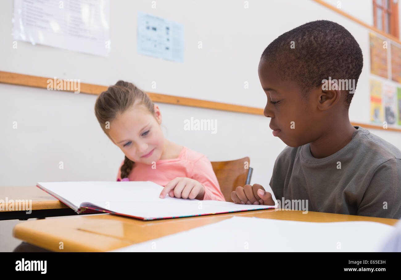 Cute pupils reading at their desks Stock Photo - Alamy