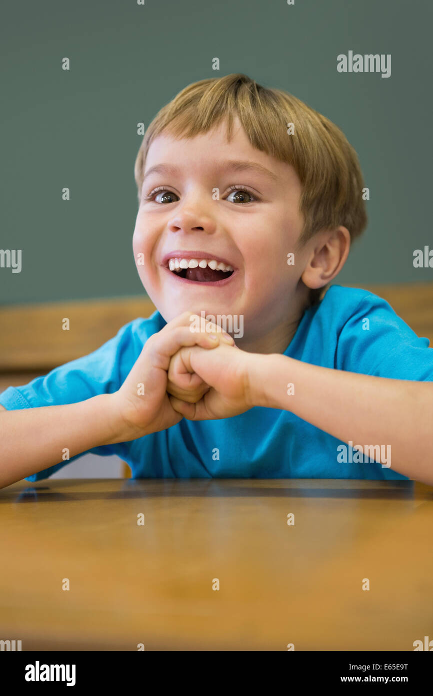Happy pupil sitting at desk in classroom Stock Photo - Alamy
