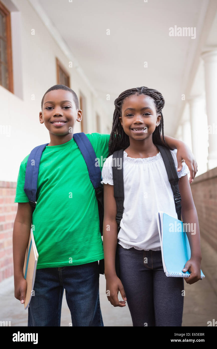Cute pupils smiling at camera in corridor Stock Photo - Alamy