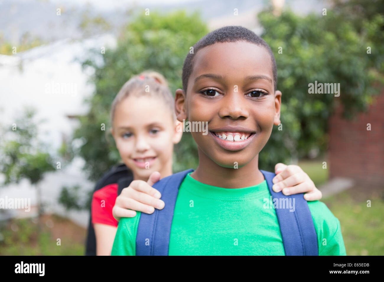 Cute pupils smiling at camera outside Stock Photo - Alamy