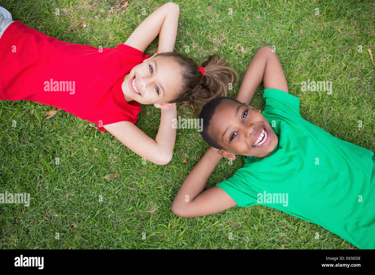 Cute children smiling at camera outside on the grass Stock Photo - Alamy