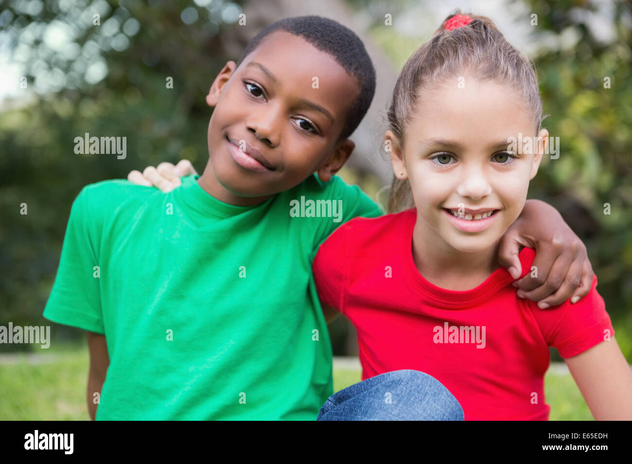 Cute children smiling at camera outside on the grass Stock Photo - Alamy
