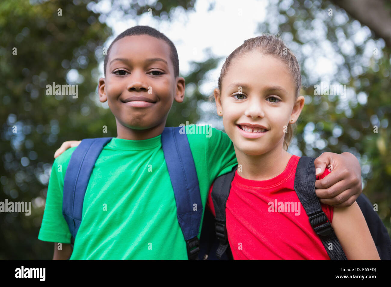 Cute pupils smiling at camera outside Stock Photo - Alamy