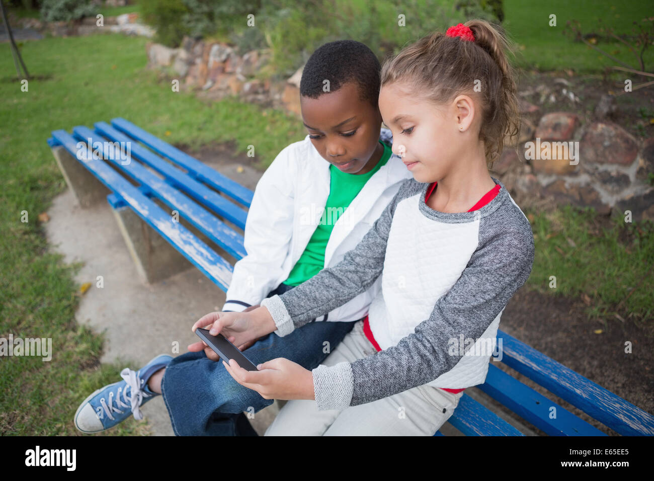 Cute little children looking at smartphone Stock Photo - Alamy