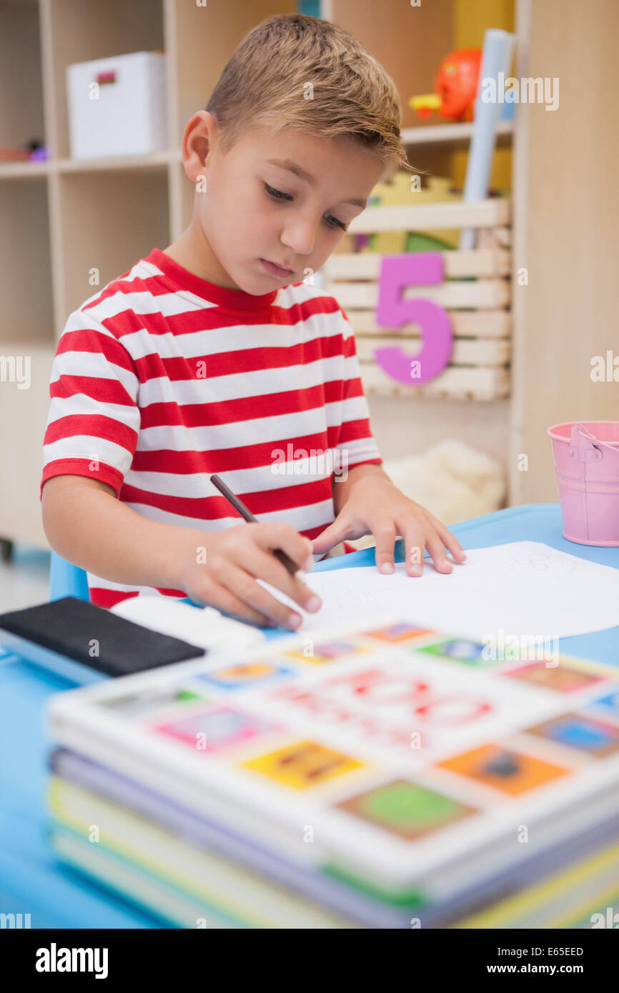 Cute little boy drawing at desk Stock Photo - Alamy