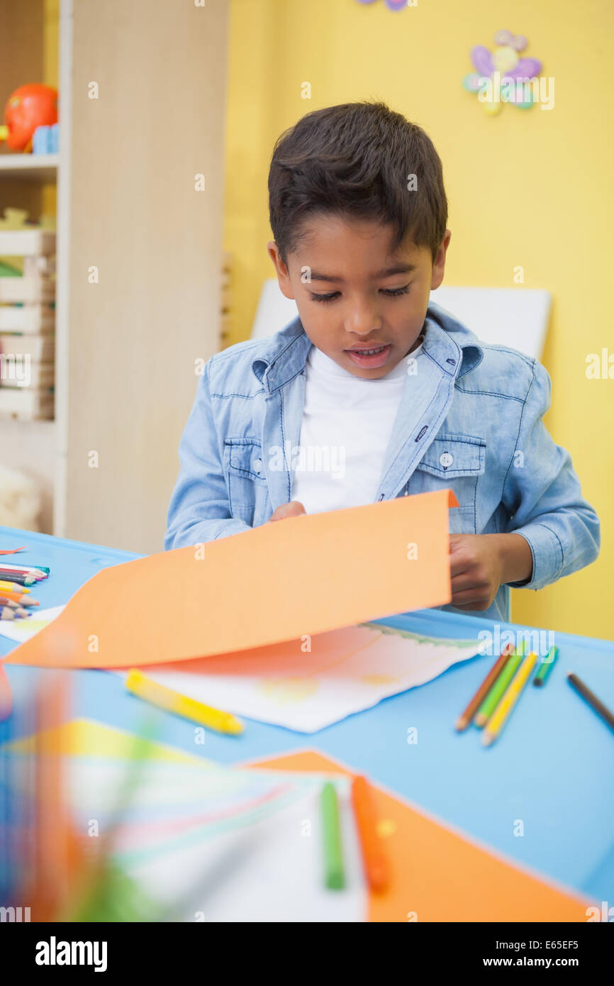 Cute little boy cutting paper shapes in classroom Stock Photo - Alamy