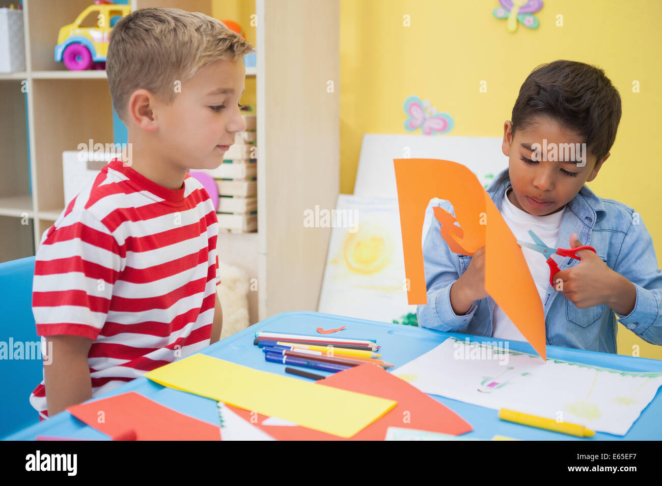 Cute little boys cutting paper shapes in classroom Stock Photo - Alamy