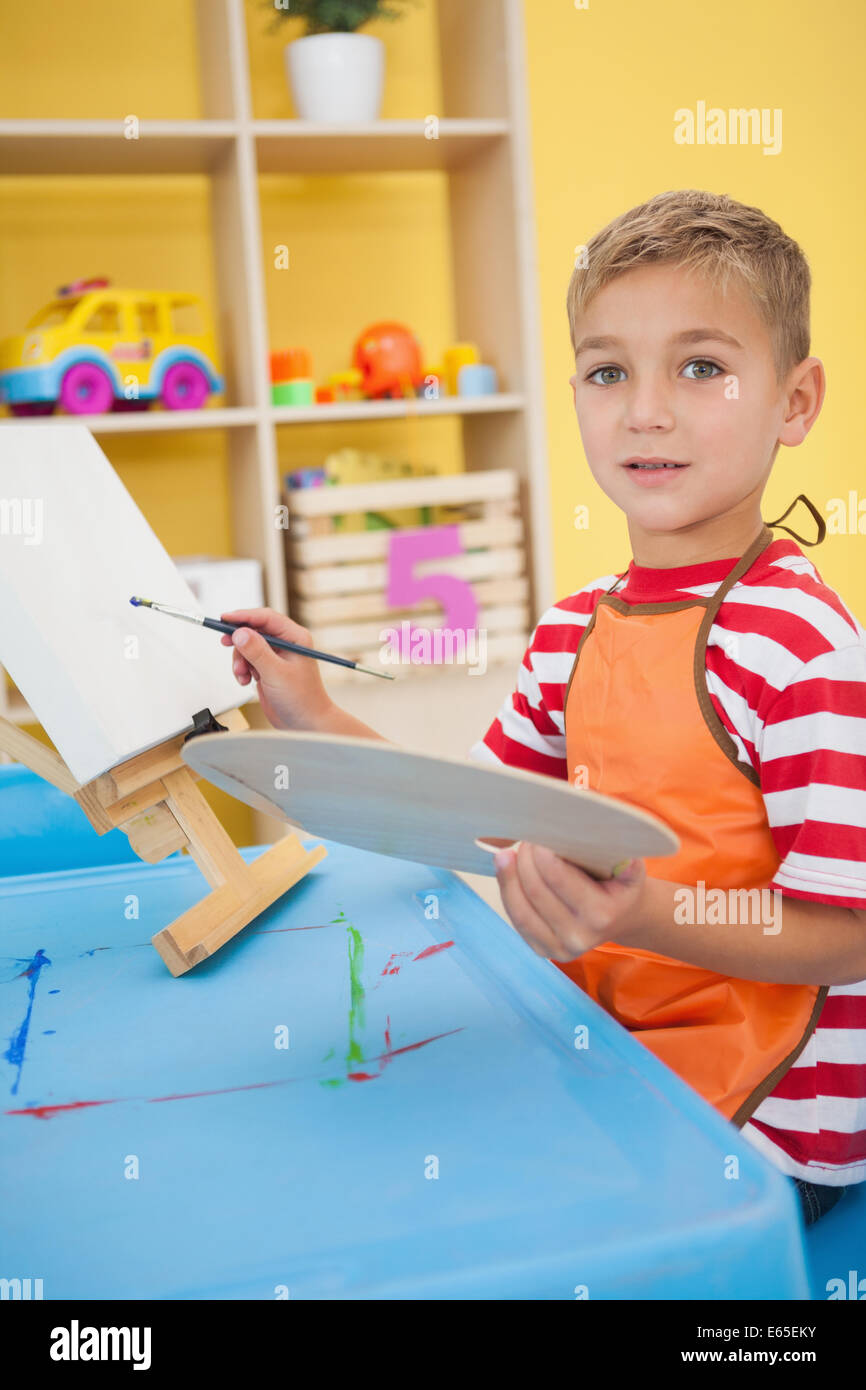 Cute little boy painting at table in classroom Stock Photo - Alamy