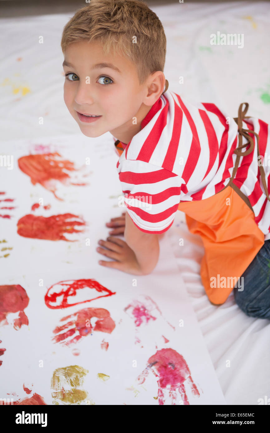 Cute little boy painting on floor in classroom Stock Photo - Alamy