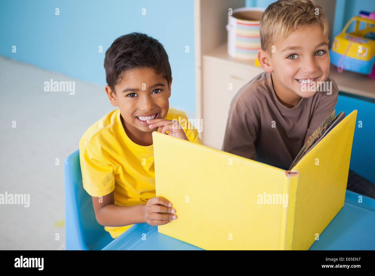 Cute little boys reading at desk in classroom Stock Photo - Alamy