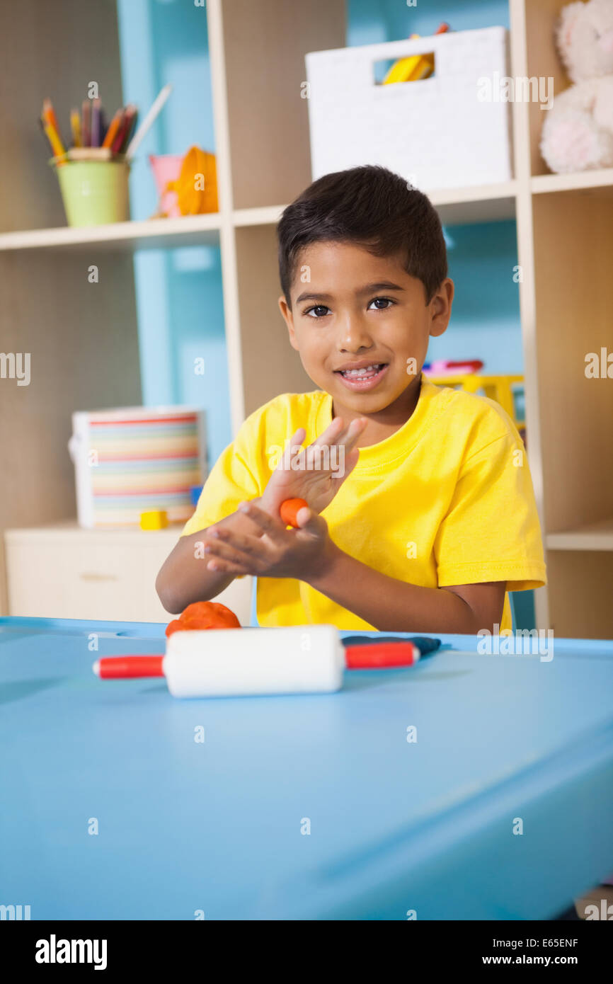 Cute little boy playing with modelling clay in classroom Stock Photo ...