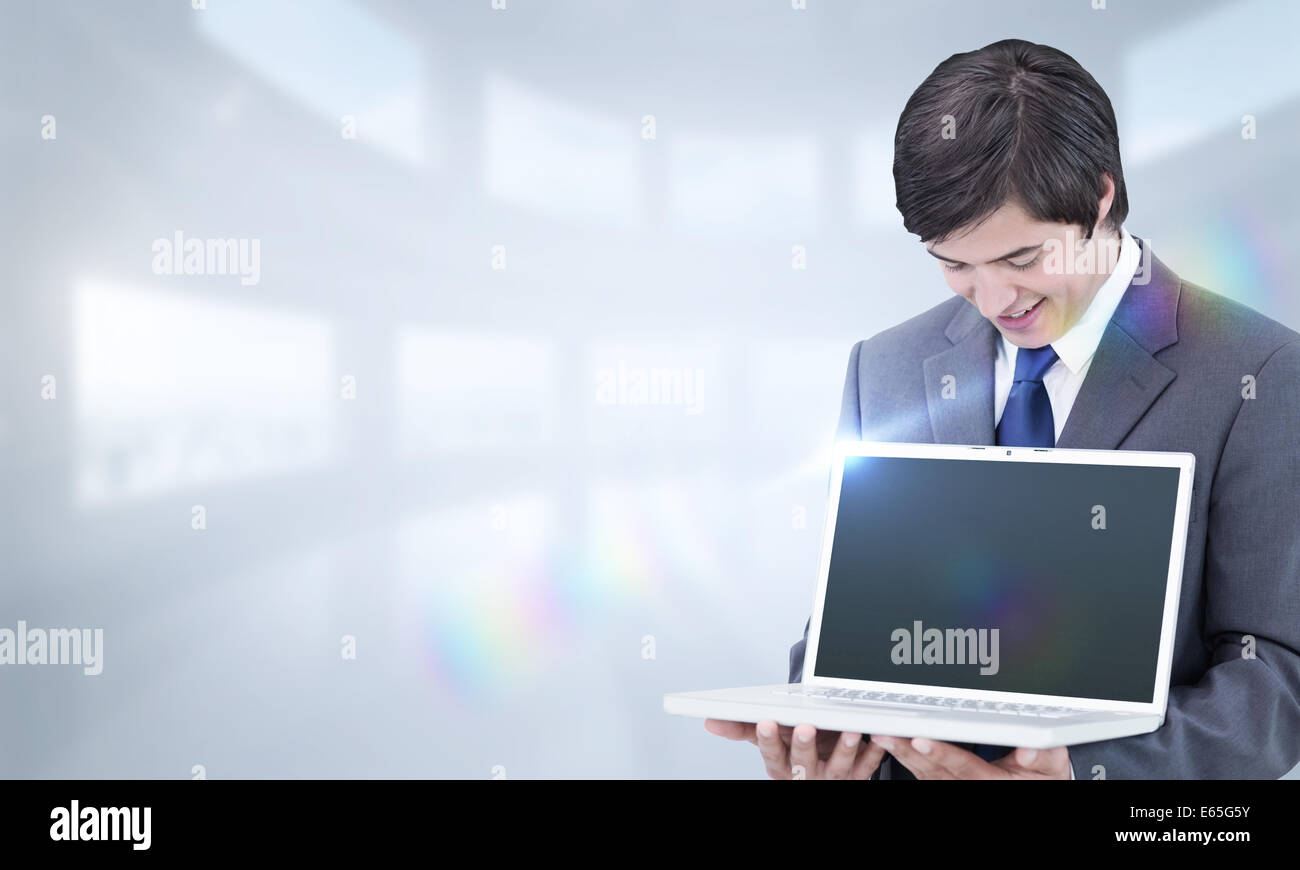 Composite image of salesman showing laptop screen with team behind him ...