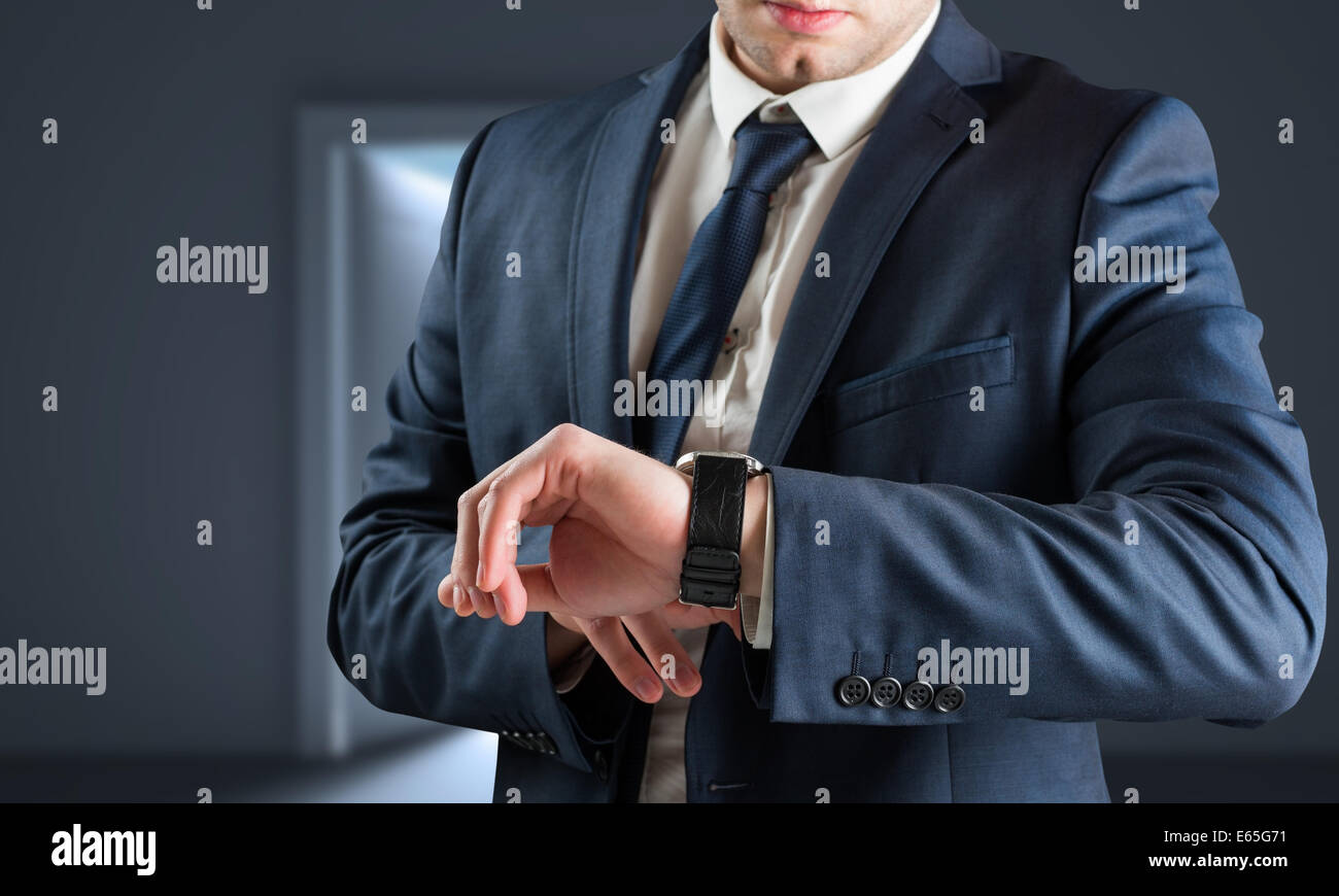 Composite image of businessman checking the time on watch Stock Photo ...