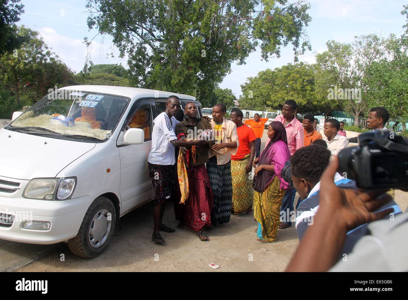 Mogadishu, Somalia. 15th Aug, 2014. People carry wounded civilians to ...