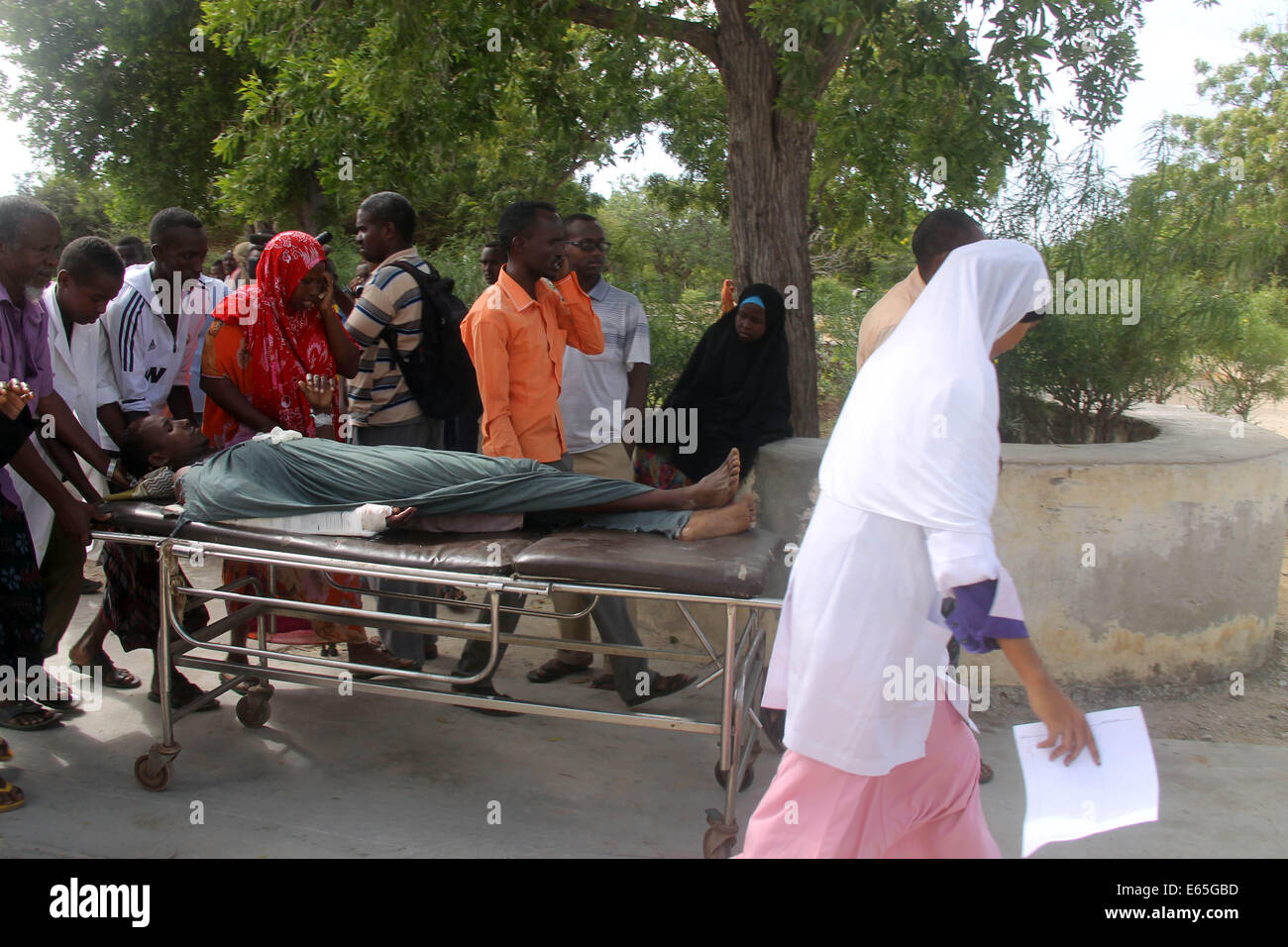 Mogadishu, Somalia. 15th Aug, 2014. People carry wounded civilians to ...