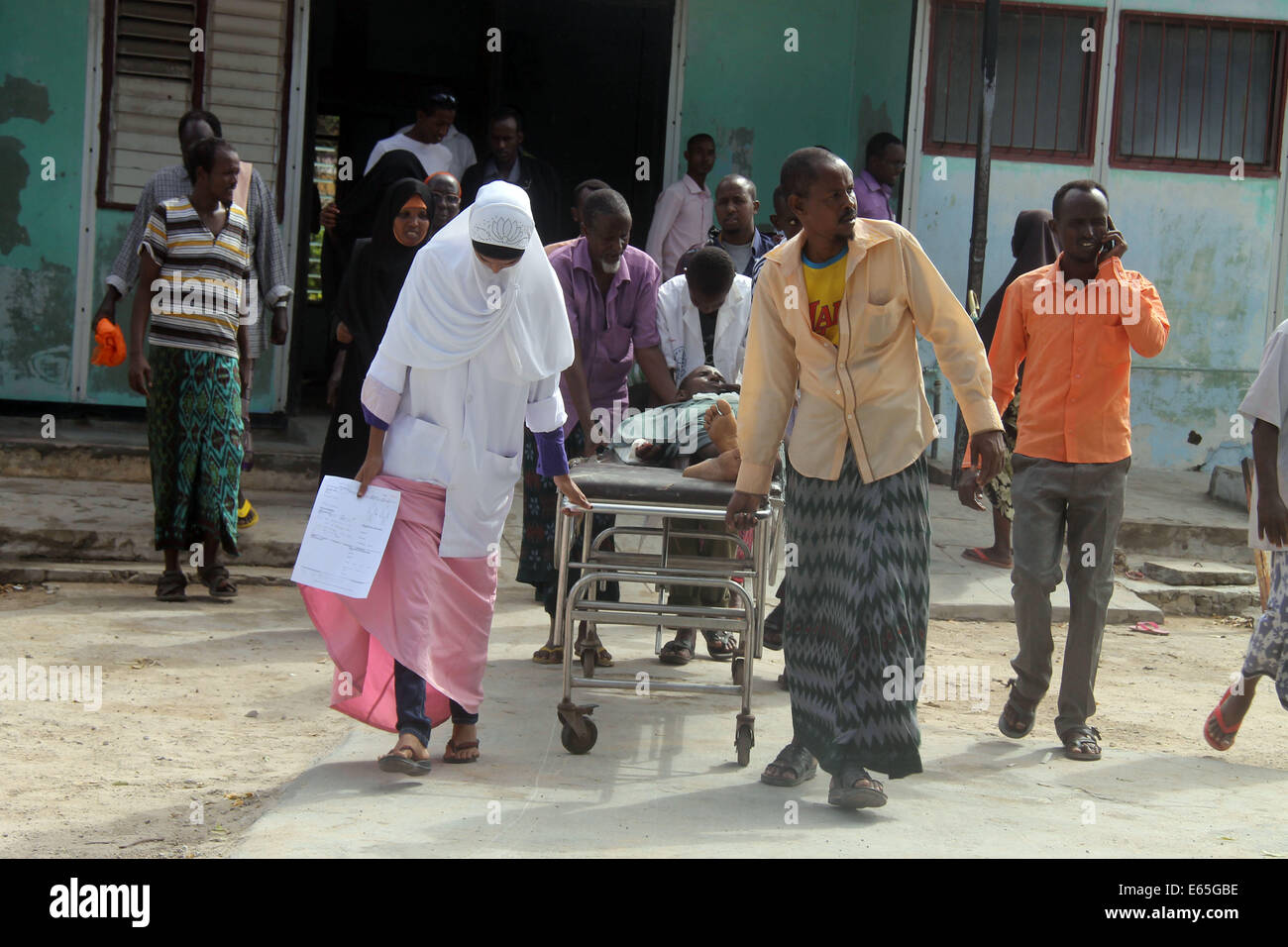 Mogadishu, Somalia. 15th Aug, 2014. People carry wounded civilians to ...