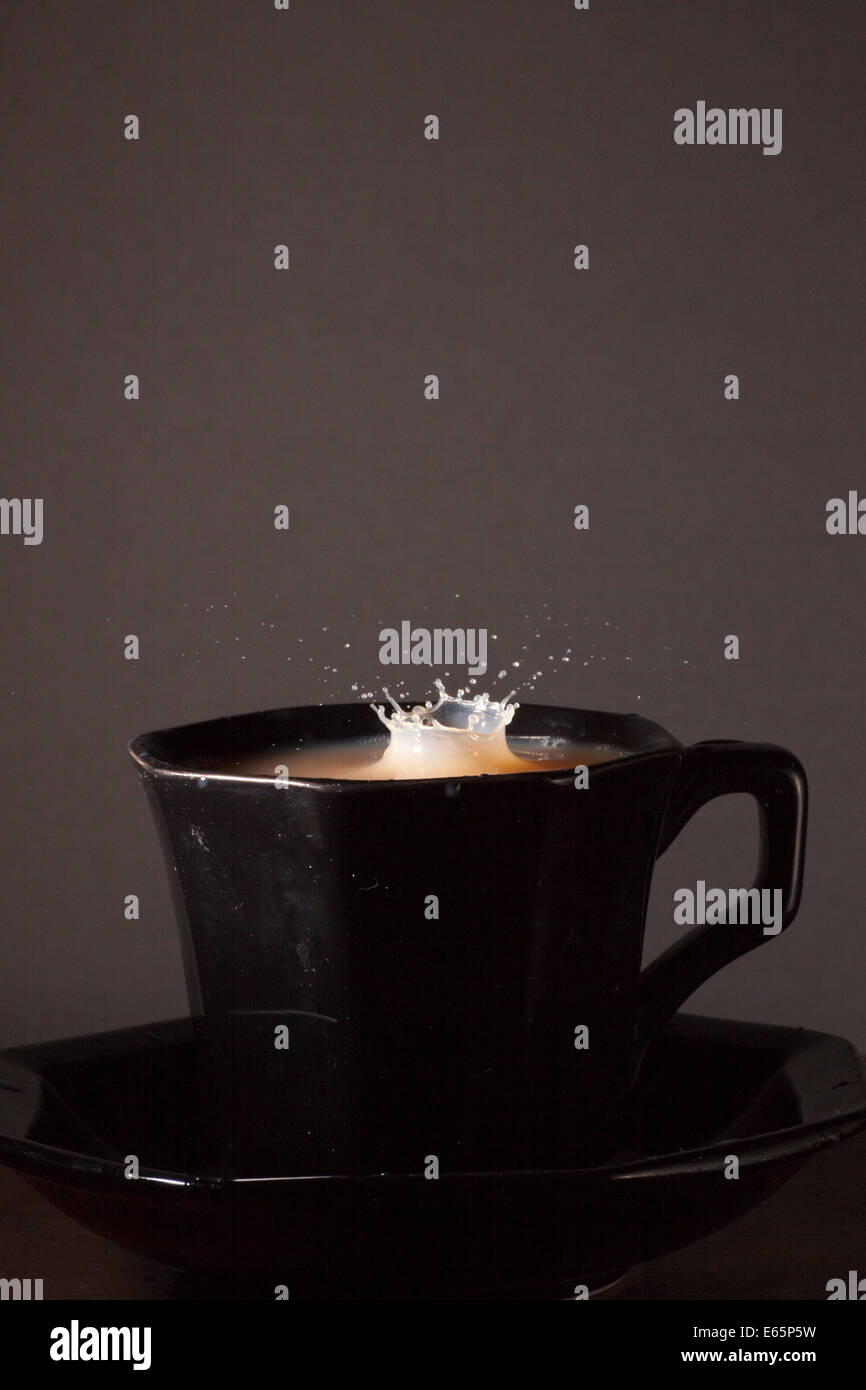 Tea being dropped in to a cup to make a splash Stock Photo - Alamy