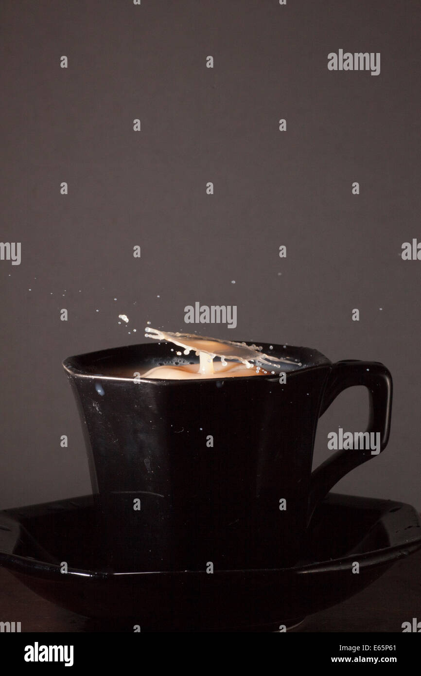 Tea being dropped in to a cup to make a splash Stock Photo - Alamy
